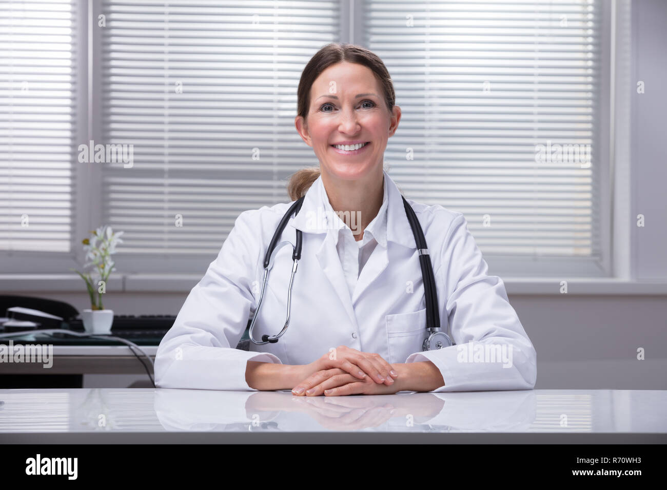 Female doctor sitting desk measure hi-res stock photography and images ...