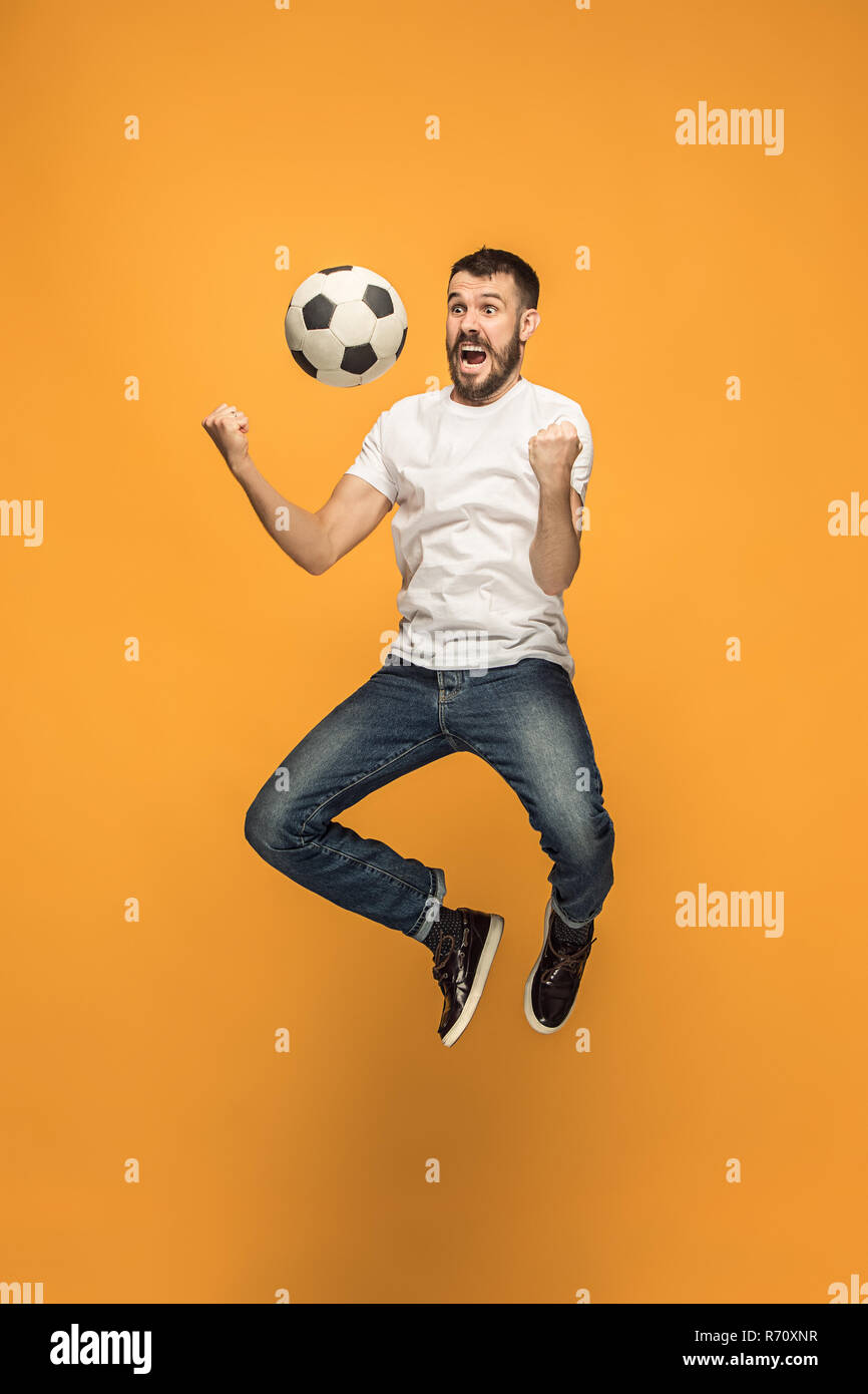 The young man as soccer football player kicking the ball at studio ...