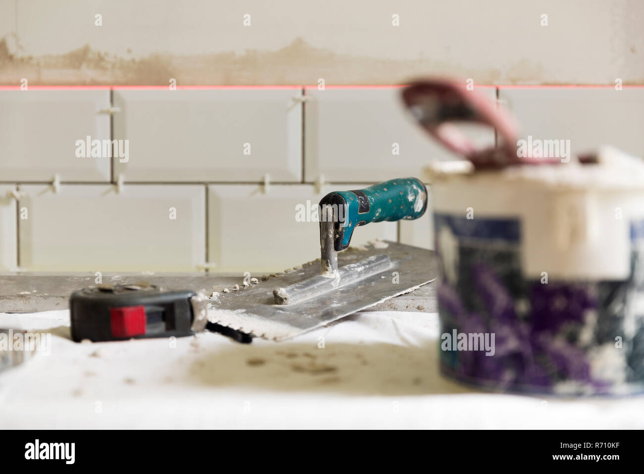 Process of tiling the tiles in the kitchen with necessary tiling tools ...