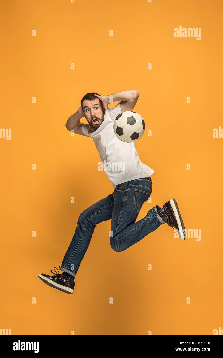The young man as soccer football player kicking the ball at studio ...