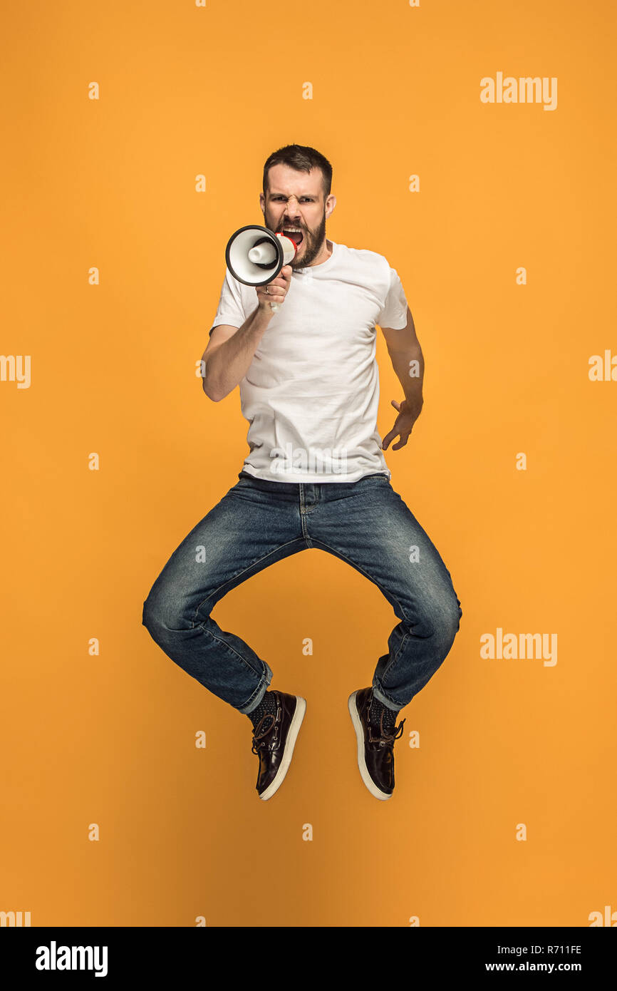Jumping fan on orange background. The young man as soccer football fan ...