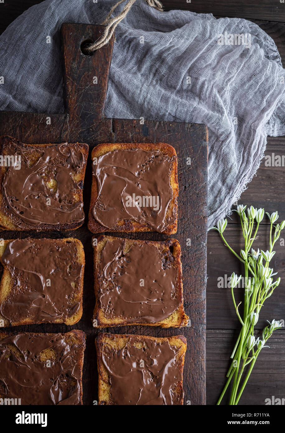square pieces of fried white bread smeared with chocolate on a brown ...
