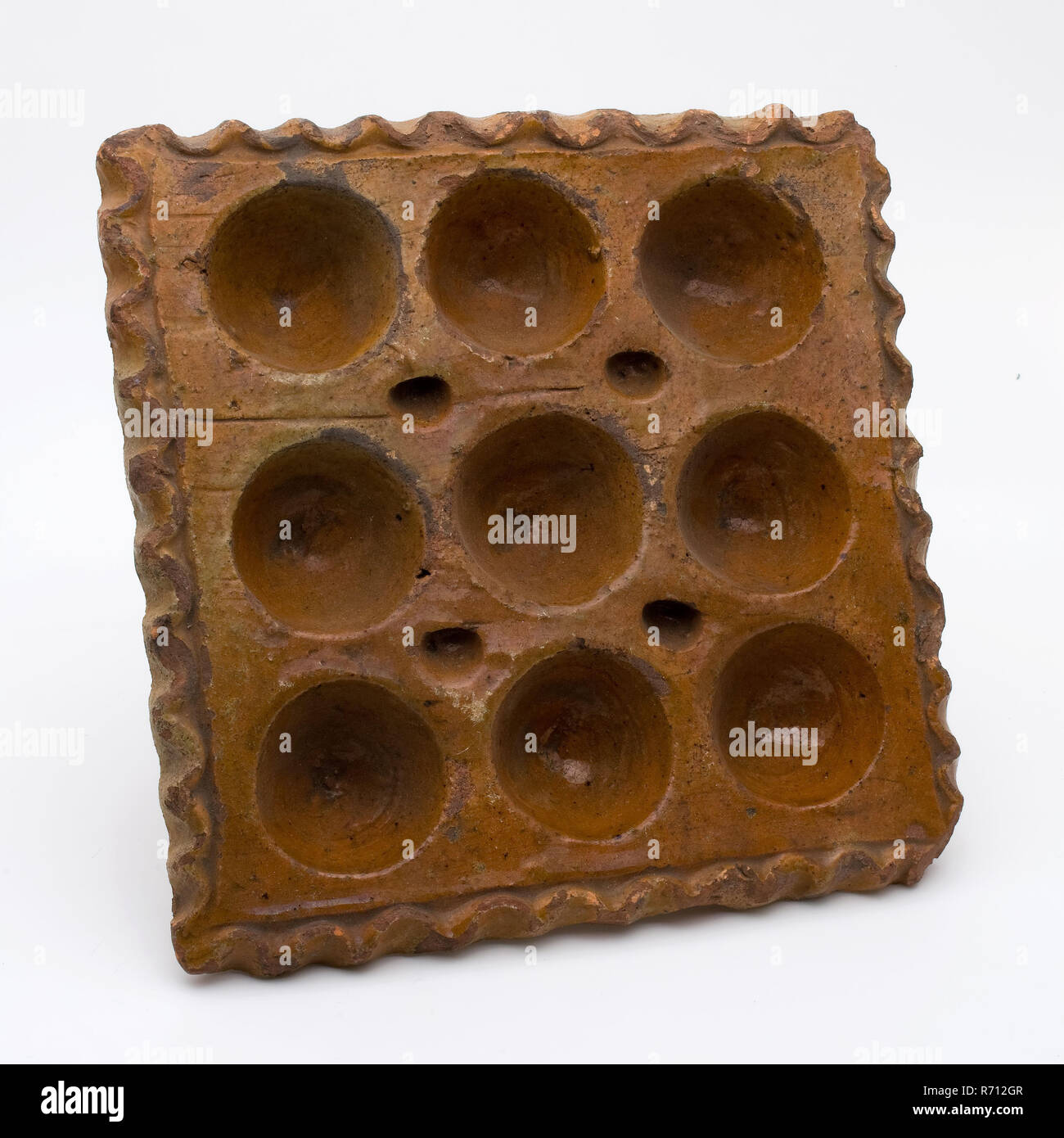 Square chicken drinking trough or chick stone, delineated by wavy rim ...