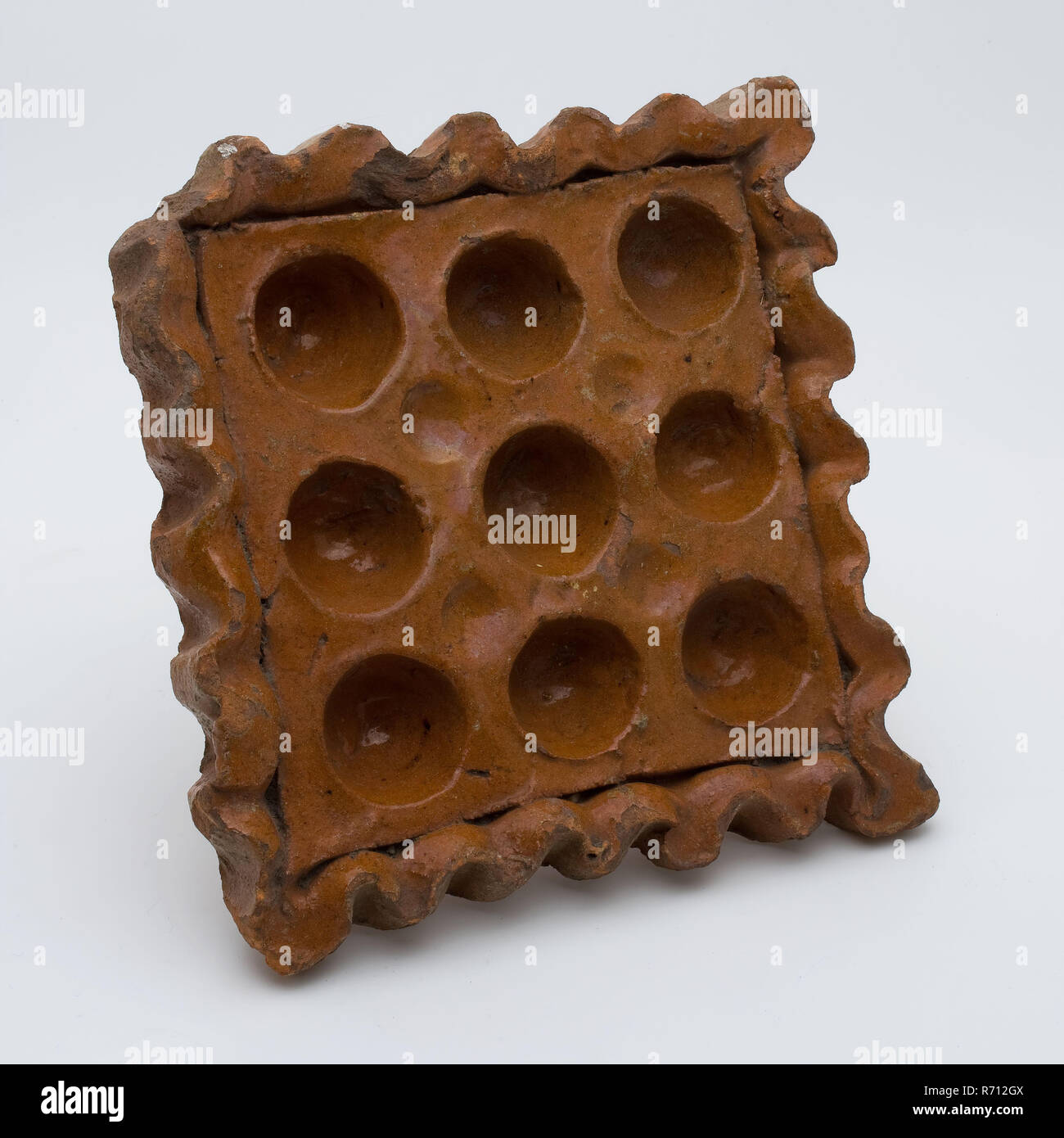 Square chicken drinking trough or chick stone, delineated by wavy rim ...