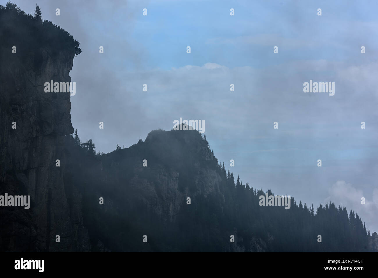 Overhanging cliffs, rocky slopes mountain range with trees Stock Photo ...