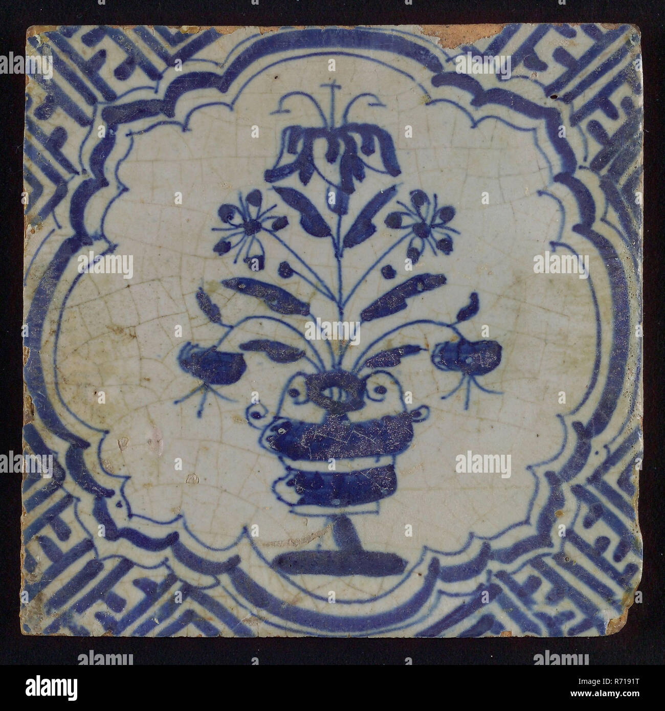 Tile with blue pot with flowers in braid-shaped frame; corner pattern ...