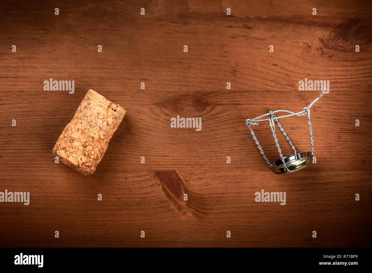 A champagne cork and closure, shot from the top on a dark rustic wooden ...