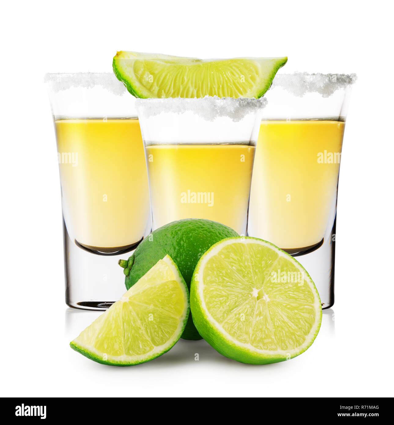 Three glasses of golden tequila with whole and sliced lime isolated on ...