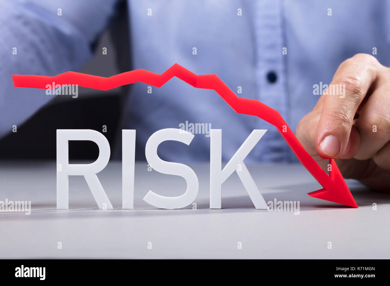 Person Pointing Diminishing Arrow Over The Risk Stock Photo - Alamy