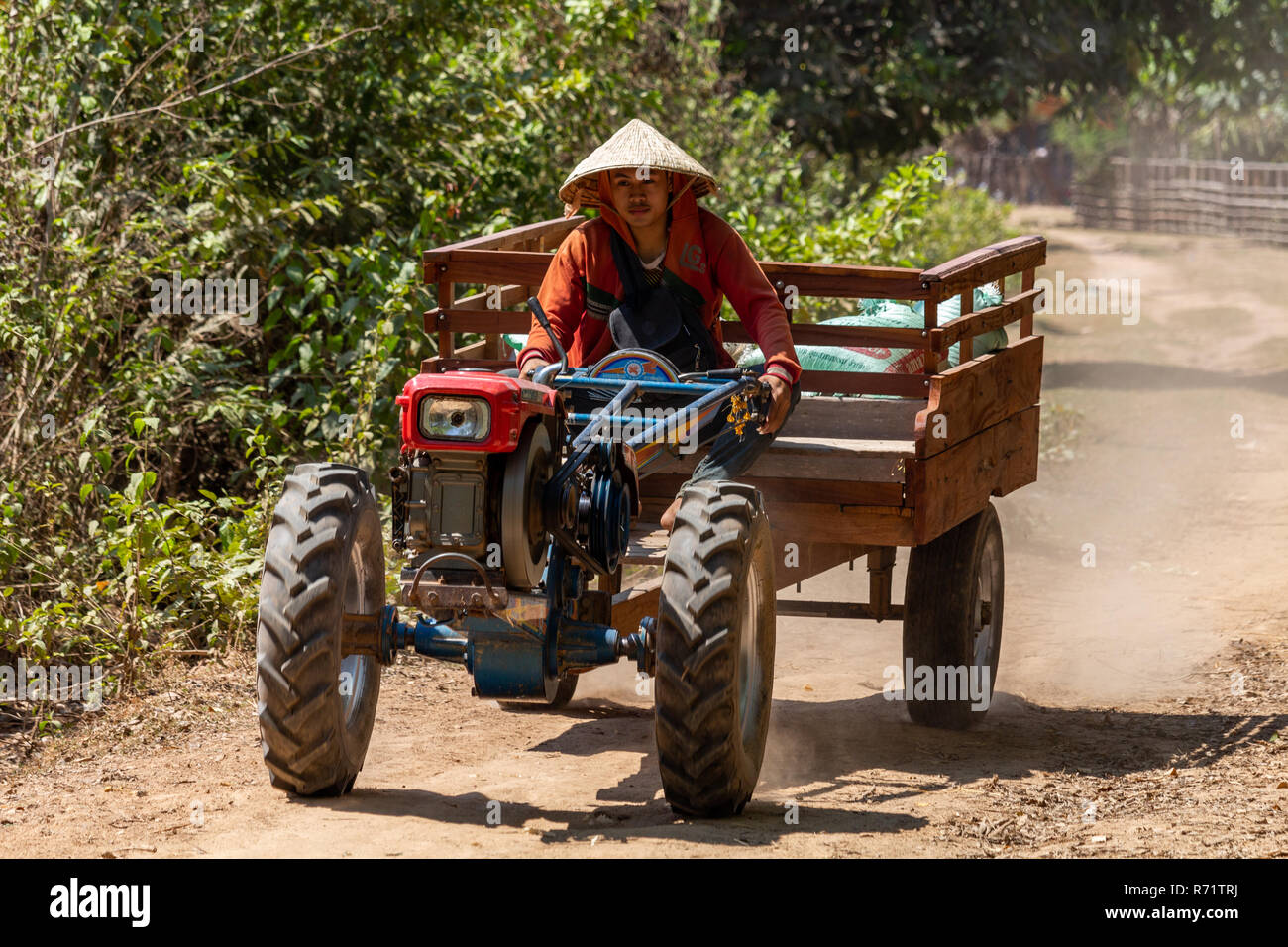 Don Daeng, Laos - April 27, 2018: Young boy driving a tractor in a ...