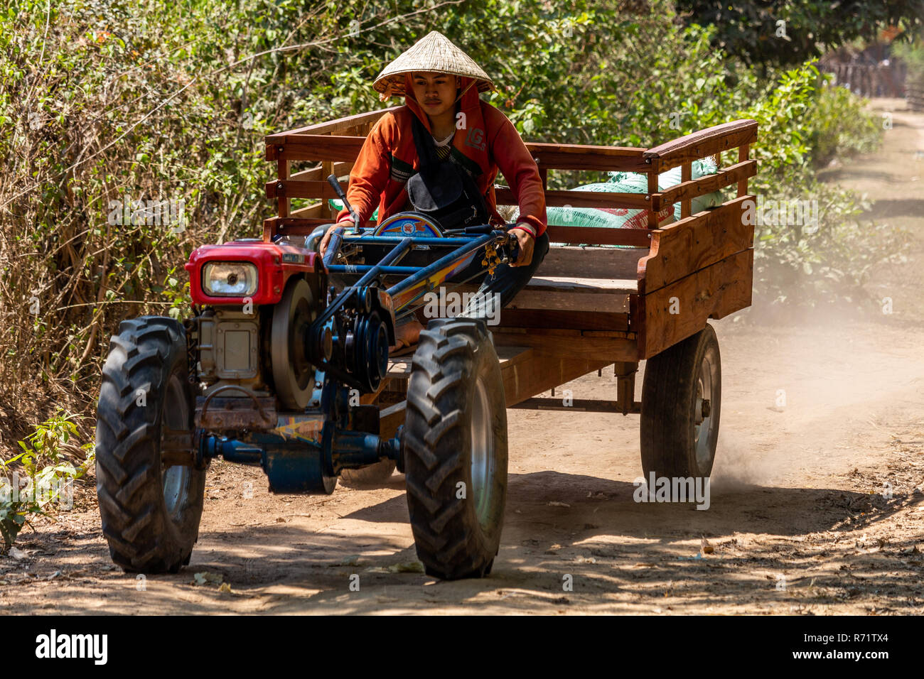 Don Daeng, Laos - April 27, 2018: Young boy driving a tractor in a ...