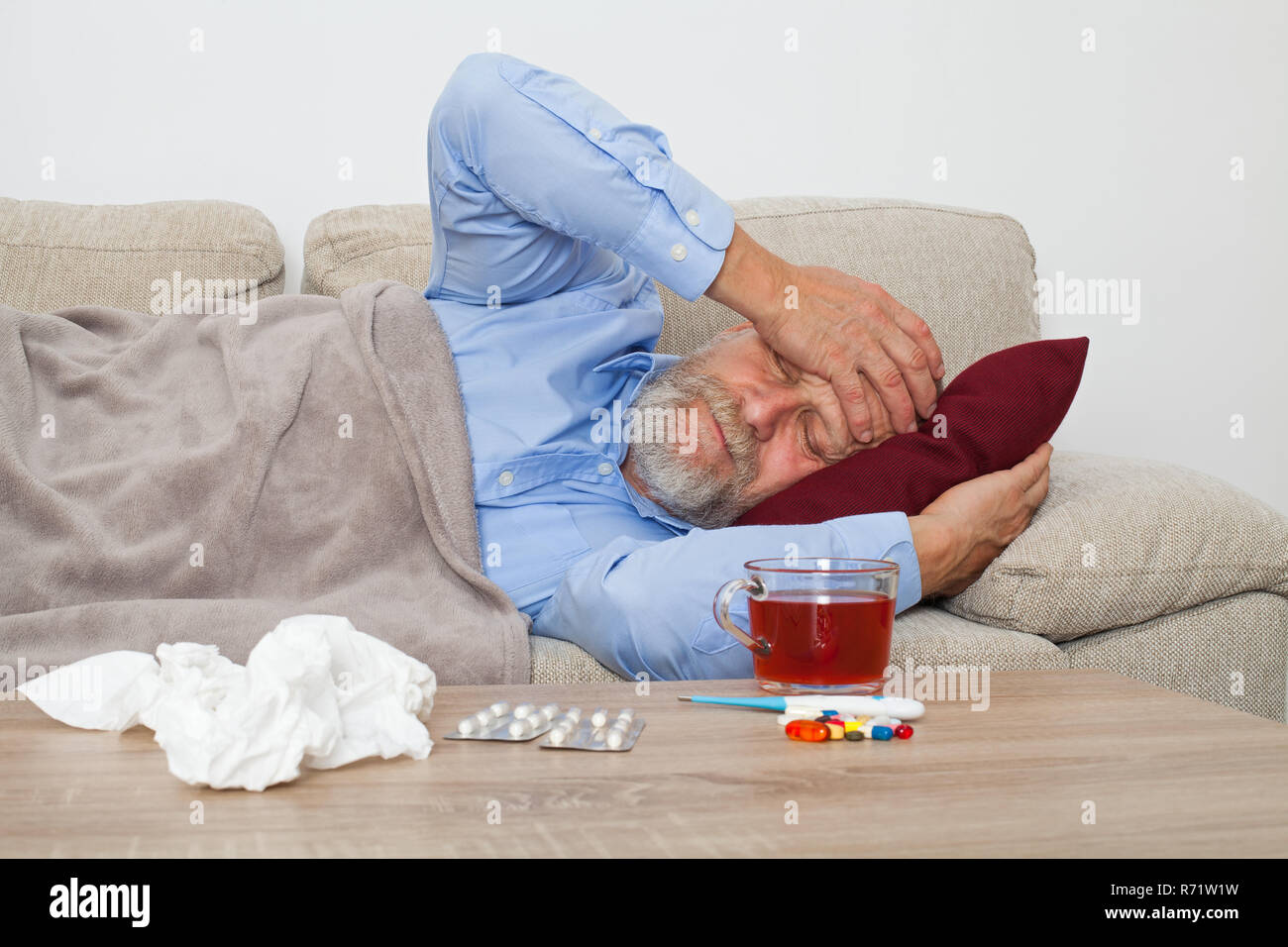 Sick senior male patient lying on the couch at home Stock Photo - Alamy