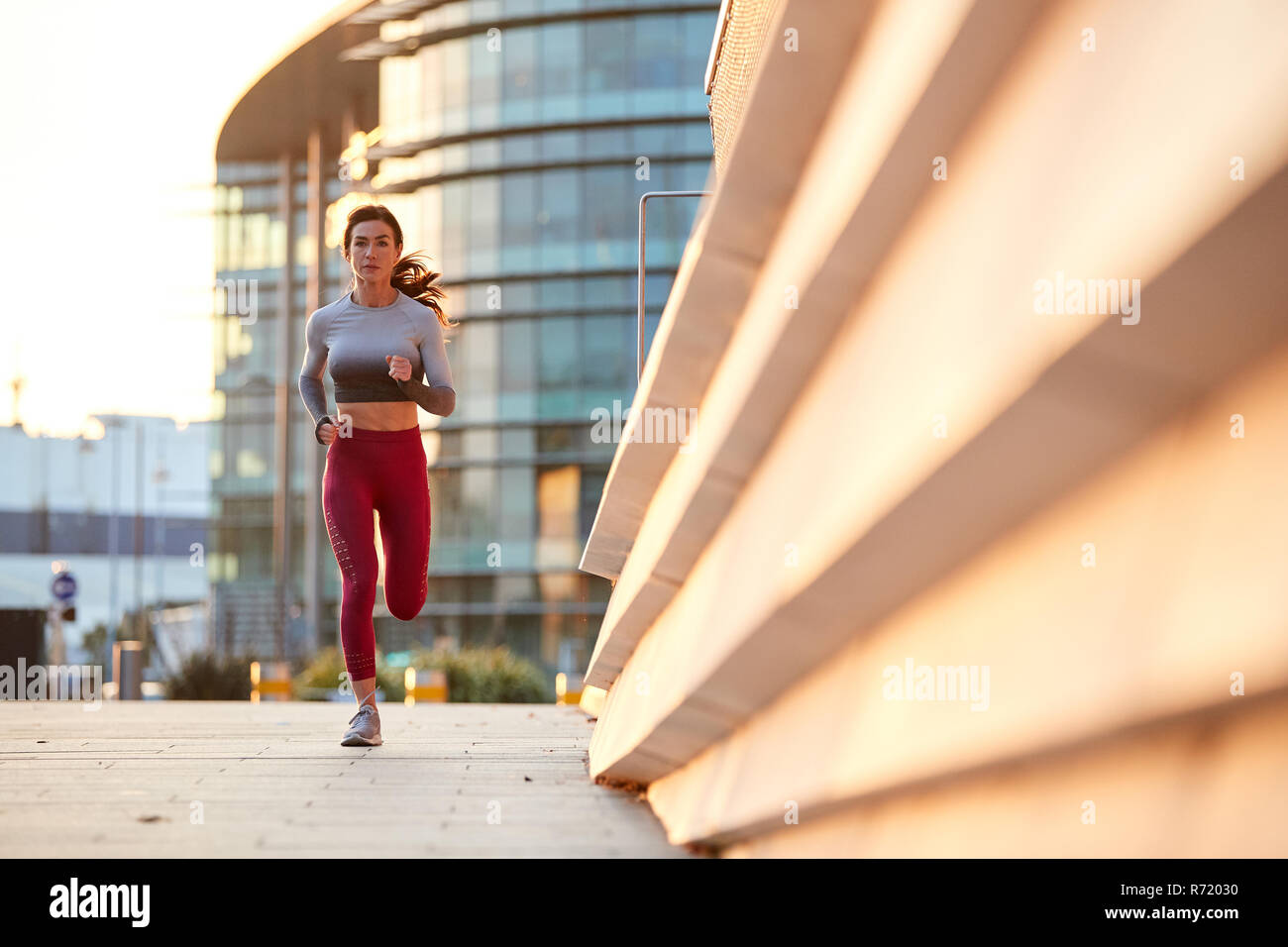 Single Caucasian Female jogging in a city centre at sunset Stock Photo ...