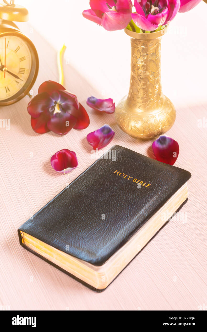 Holy Bible and old gold alarm clock on wood table Stock Photo - Alamy