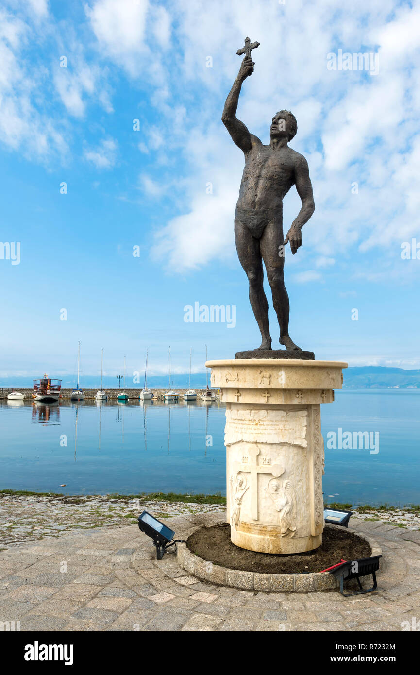 Epiphany monument, Bronze statue of a man holding a cross in his right ...
