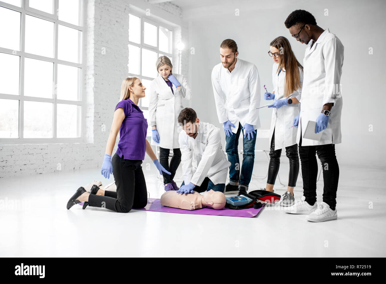 Group of young medics practising to make artificial breathing with ...