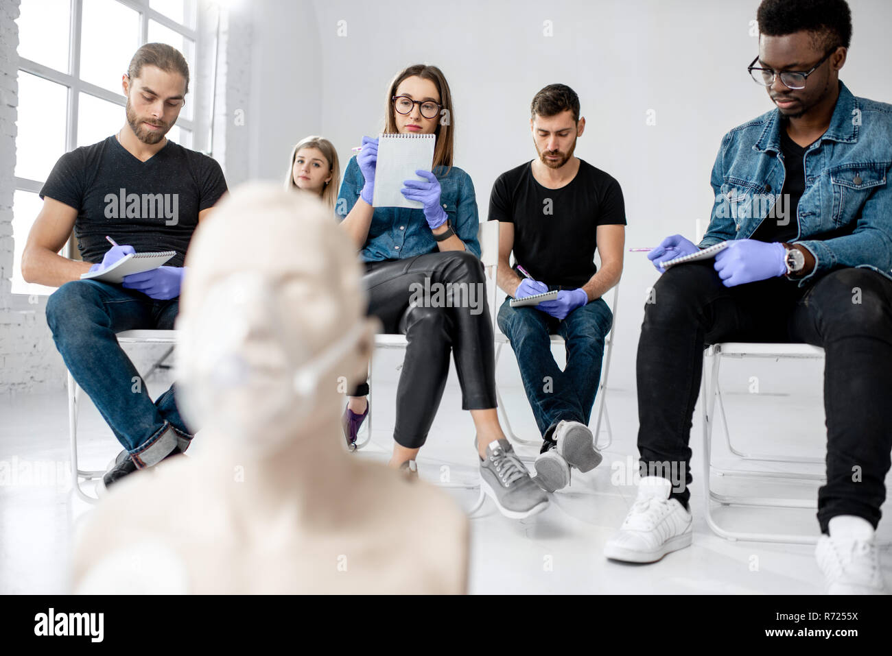 Group of young people sitting and writing during the medical first aid ...