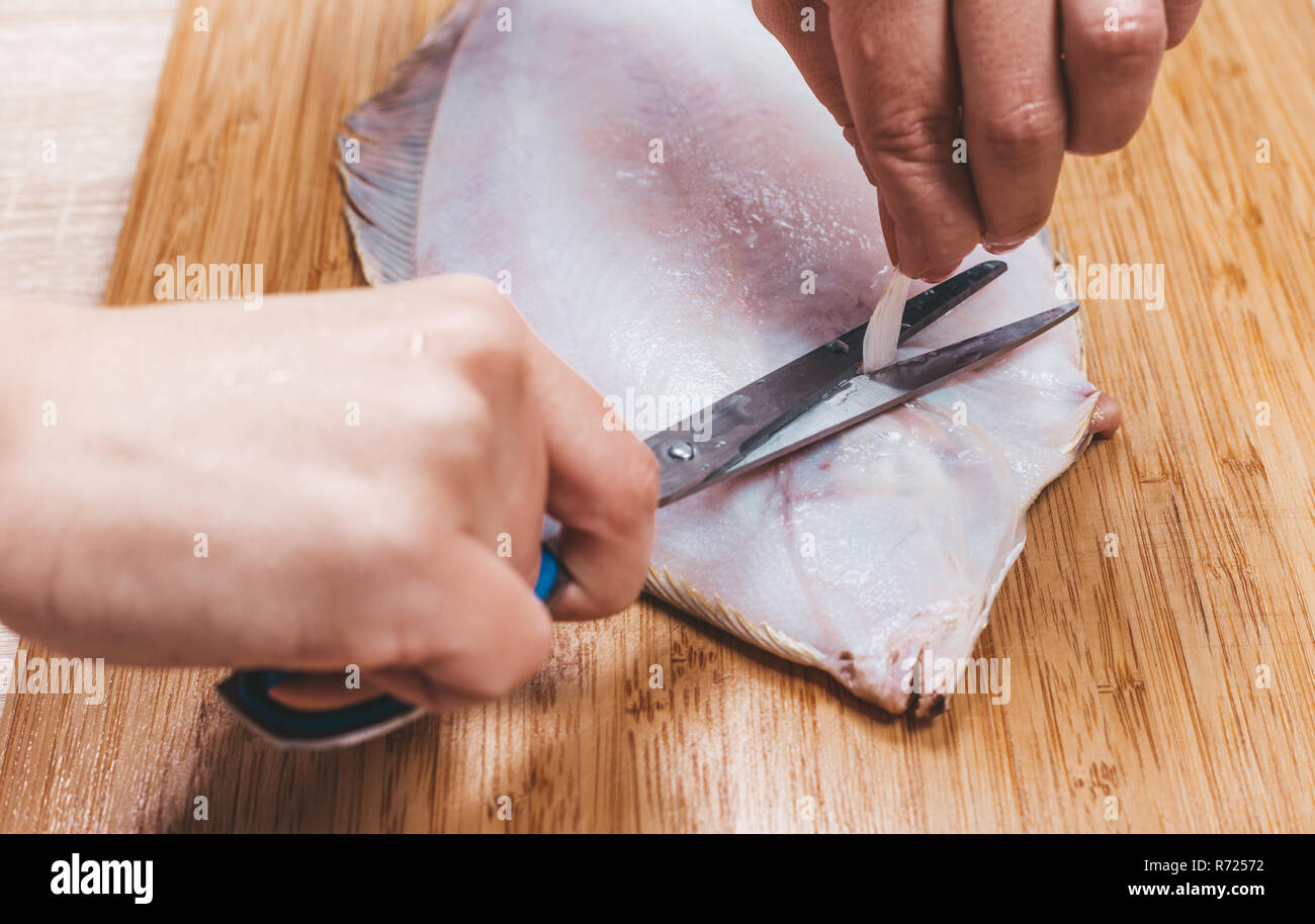 cook cutting fish flounder, female hands closeup Stock Photo - Alamy