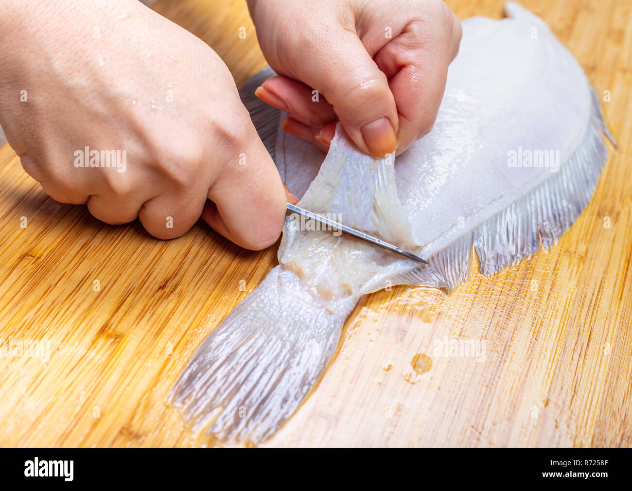 cook cutting fish flounder, female hands closeup Stock Photo - Alamy