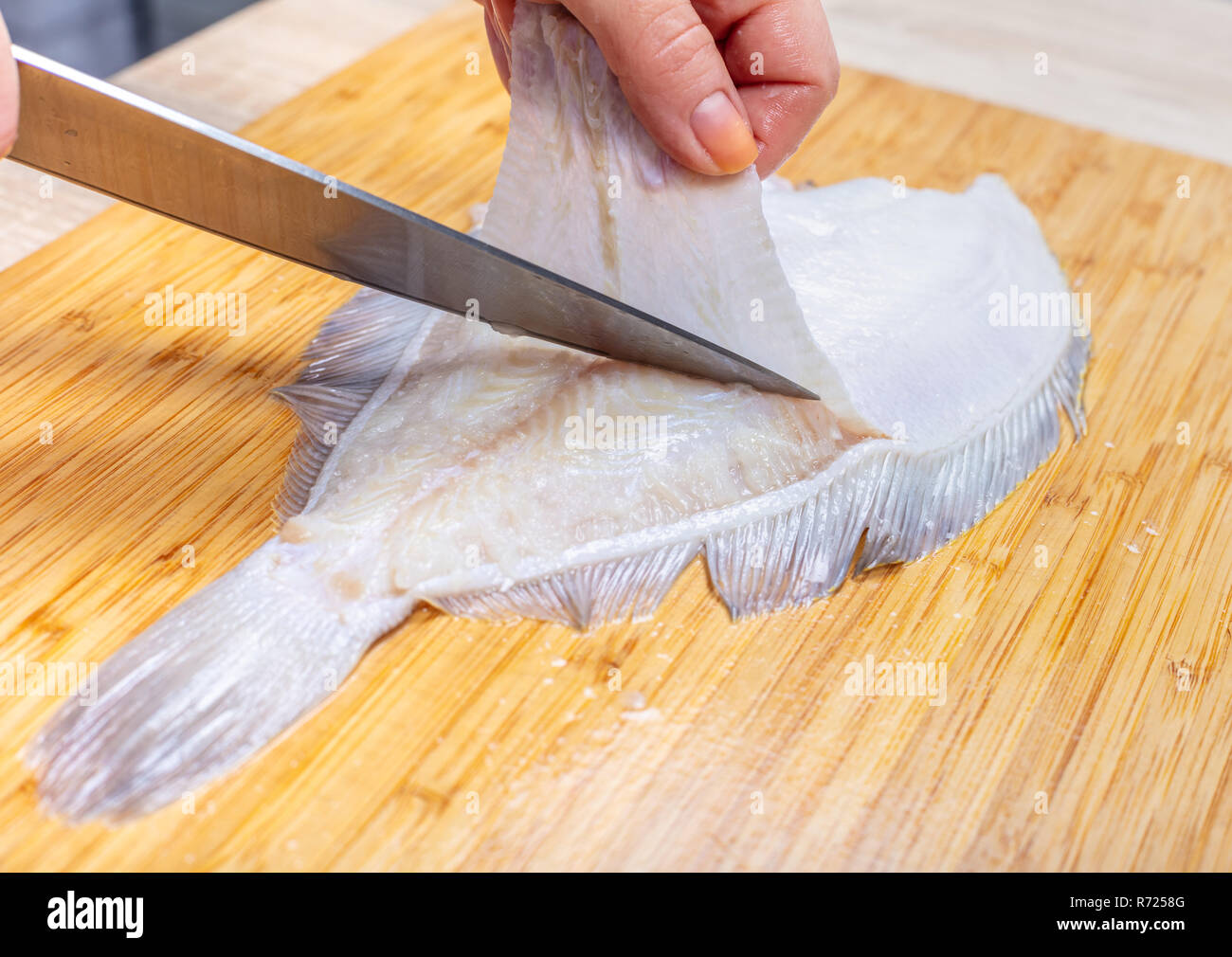 cook cutting fish flounder, female hands closeup Stock Photo - Alamy