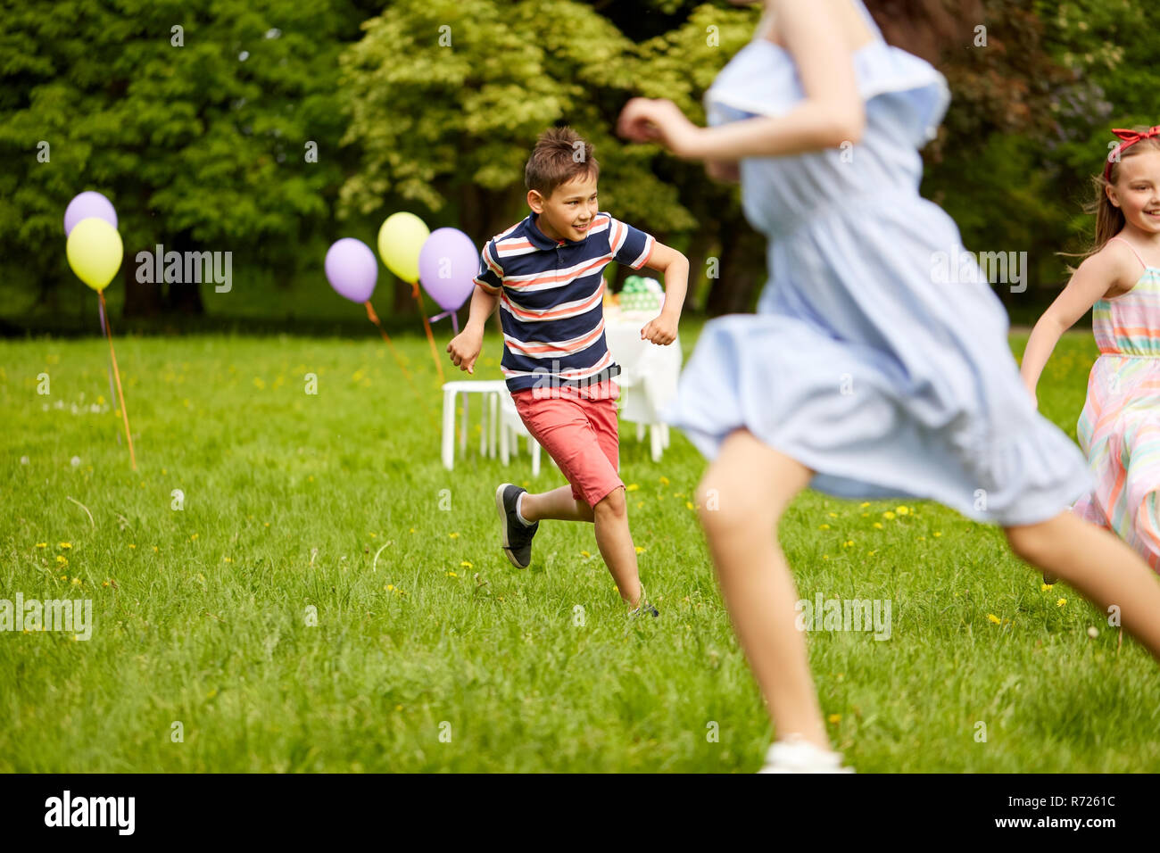 happy kids playing tag game at birthday party Stock Photo - Alamy
