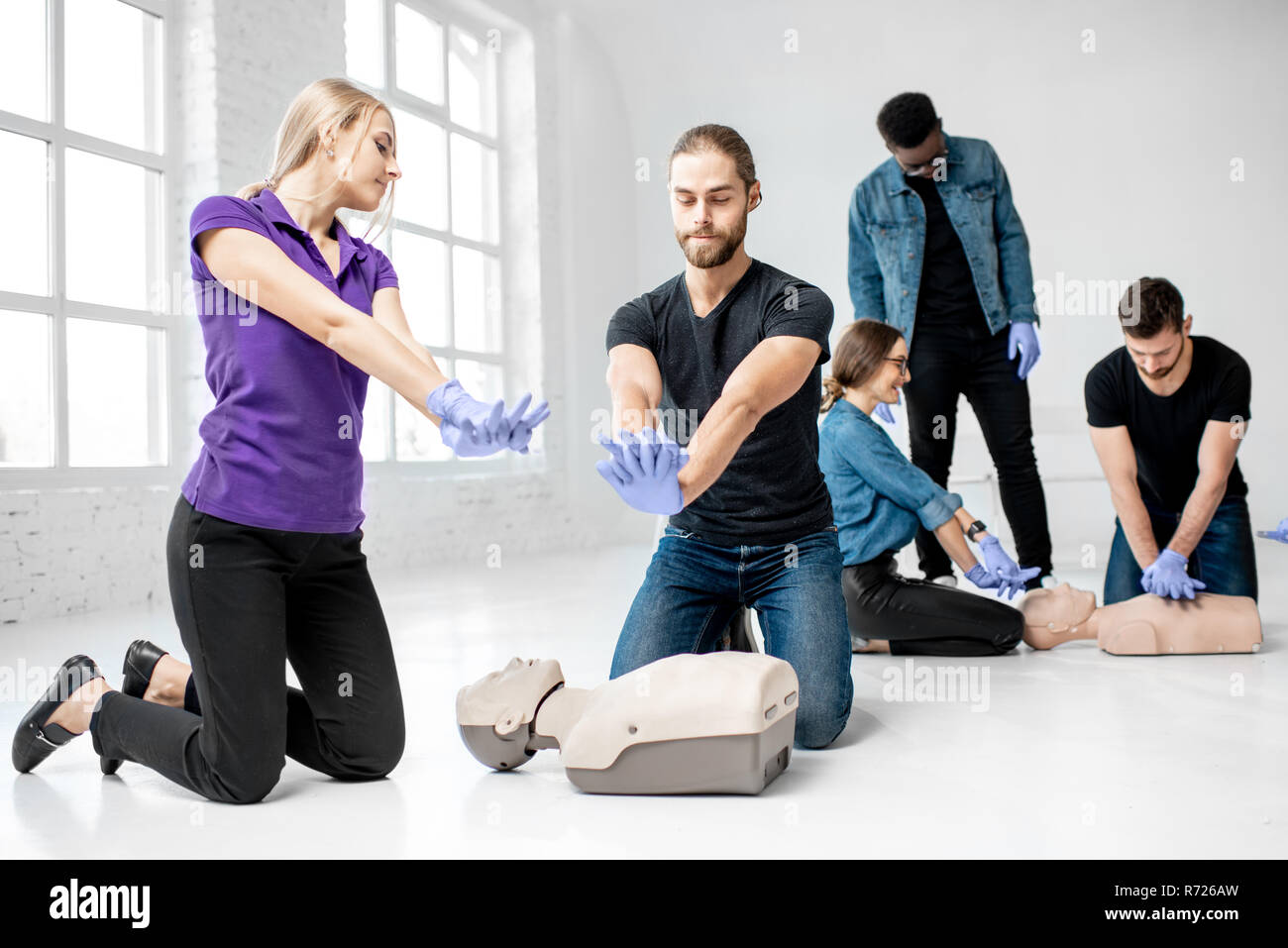 Group of young people practising to make artificial breathing with ...