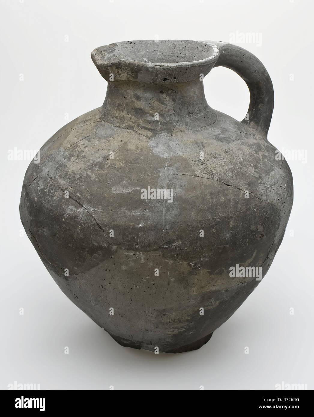Gray jug with ear and spout, on four stand fins, cuff collar around the ...