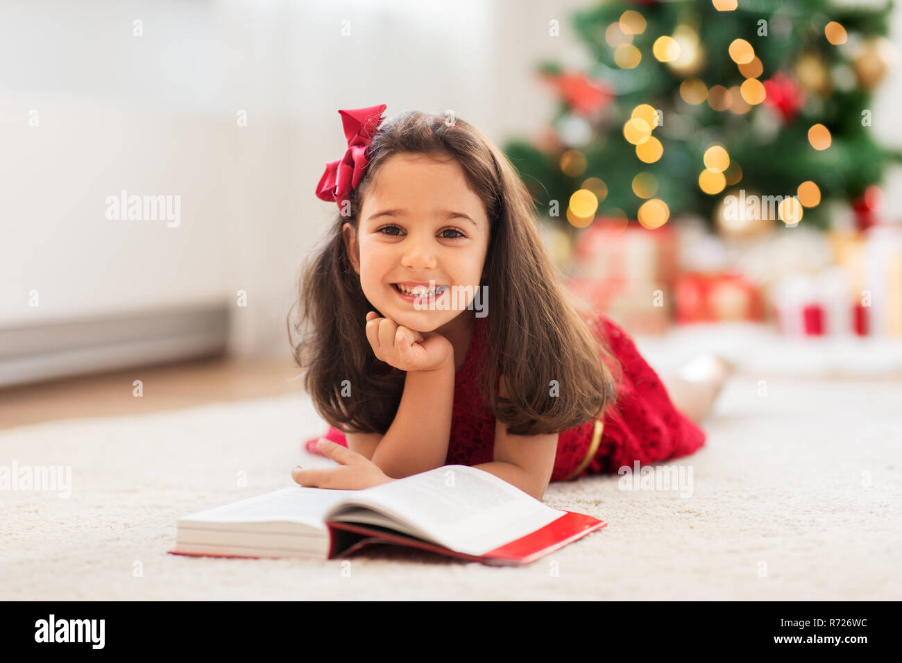 happy girl reading book at home on christmas Stock Photo - Alamy