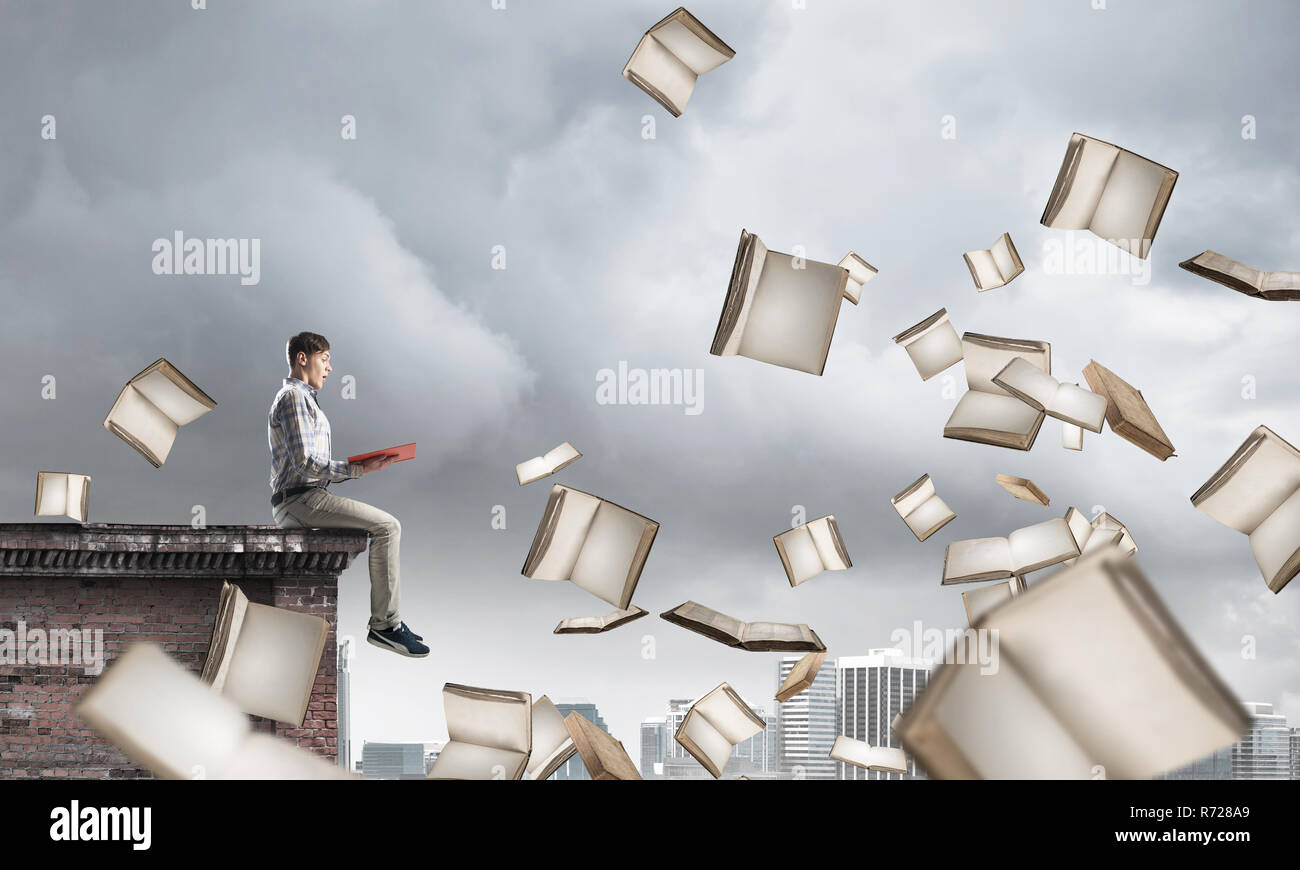 Man reading book and many of them flying in air Stock Photo - Alamy