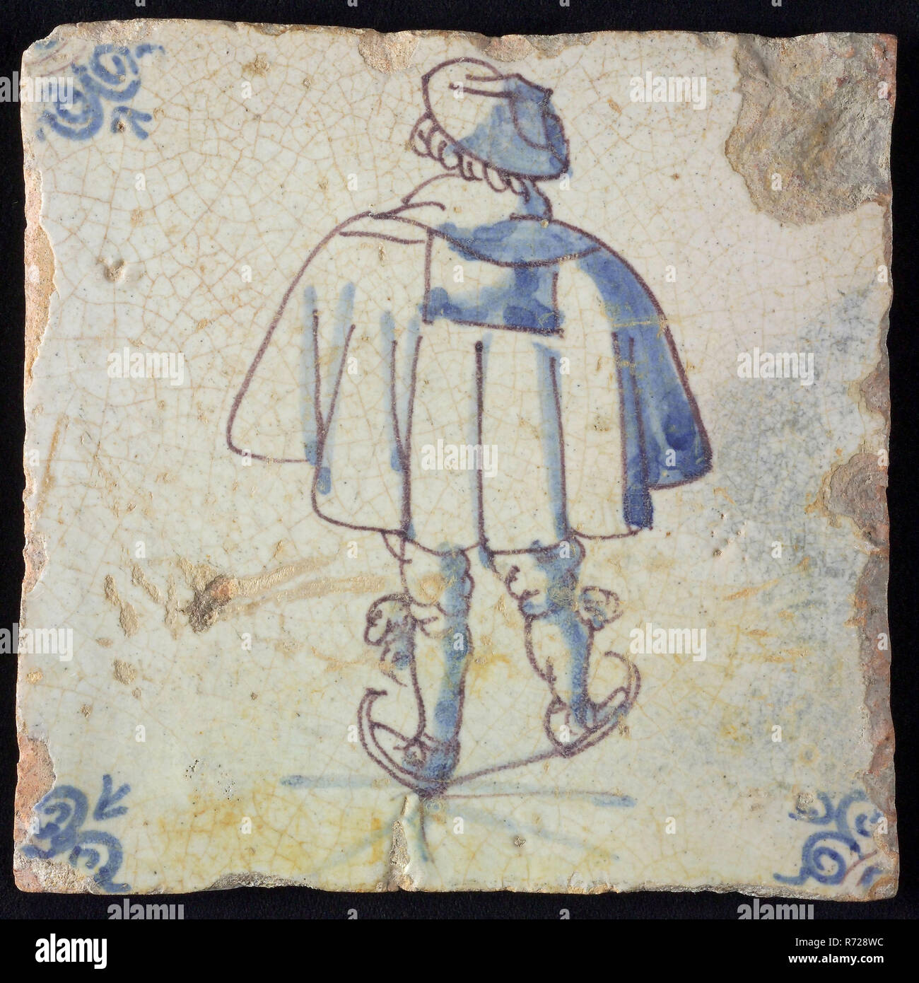 Figure tile, blue with skating man, with wide cape, seen on the back ...