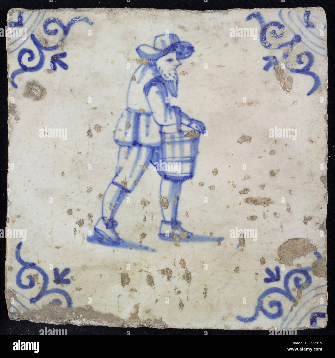Figure tile, blue with running figure with beard and bucket on the arm ...