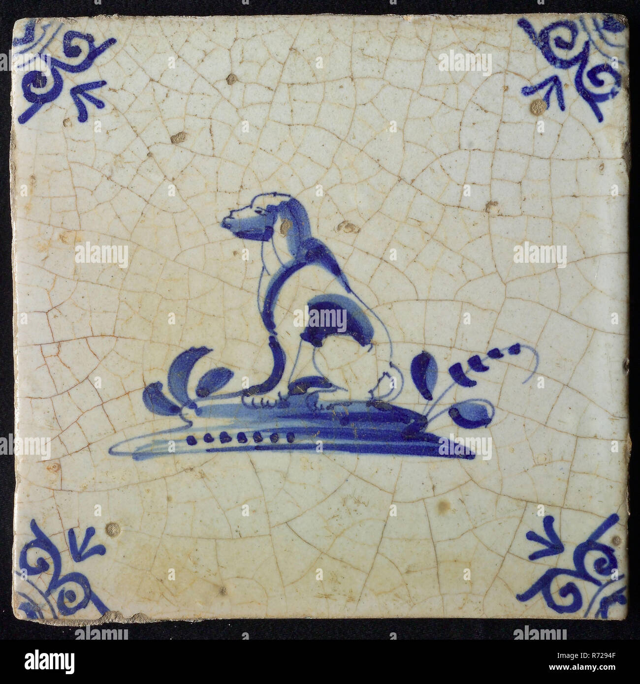 Animal tile, sitting dog to the left on plot, in blue on white, corner ...