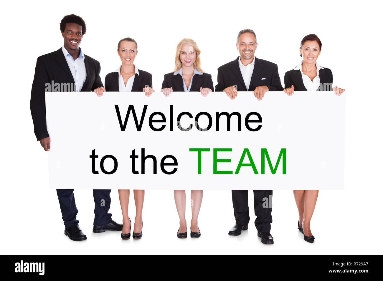 Group Of Smiling Businesspeople Holding Welcome To The Team Placard On ...