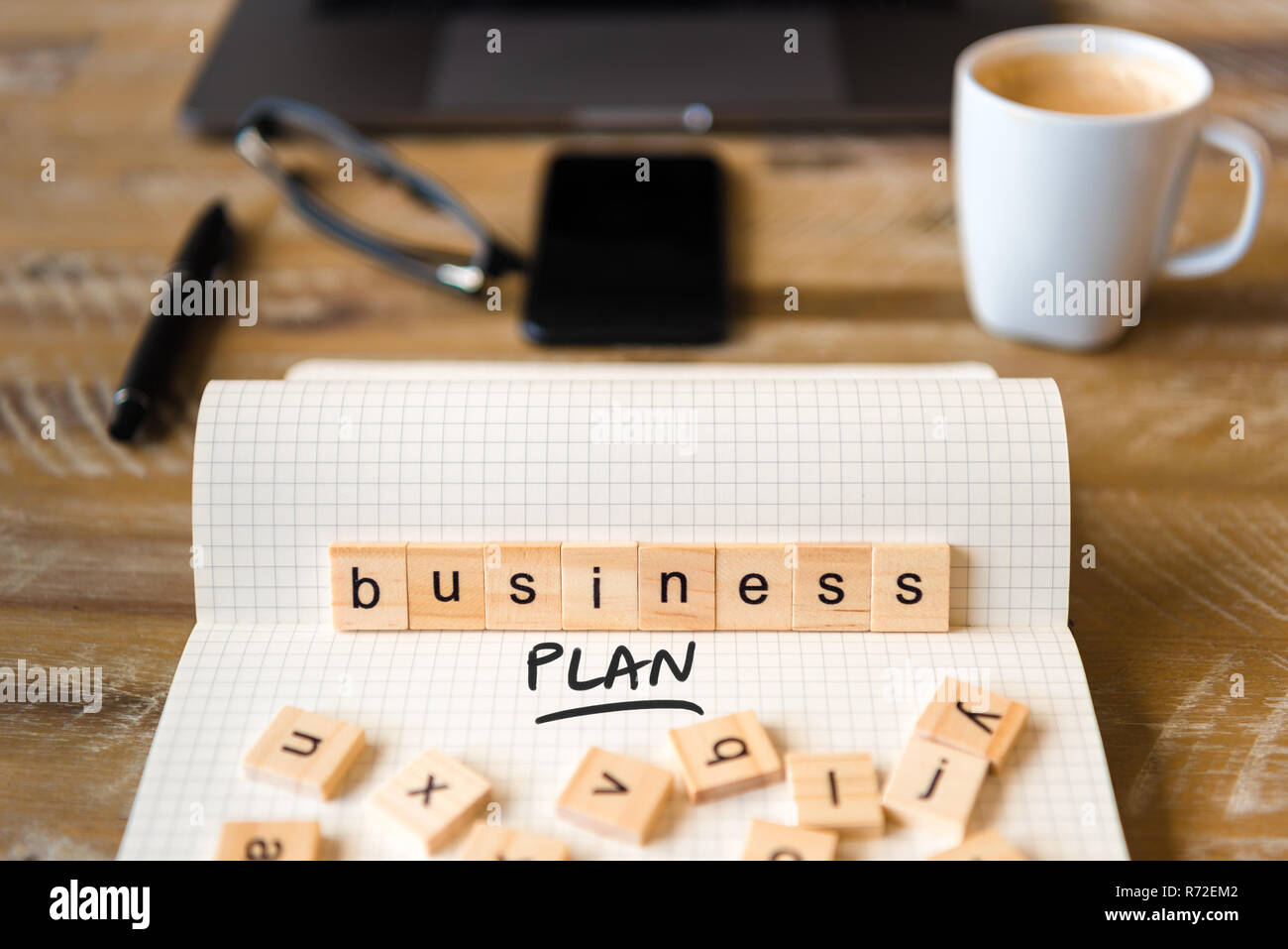 Closeup on notebook over wood table background, focus on wooden blocks ...