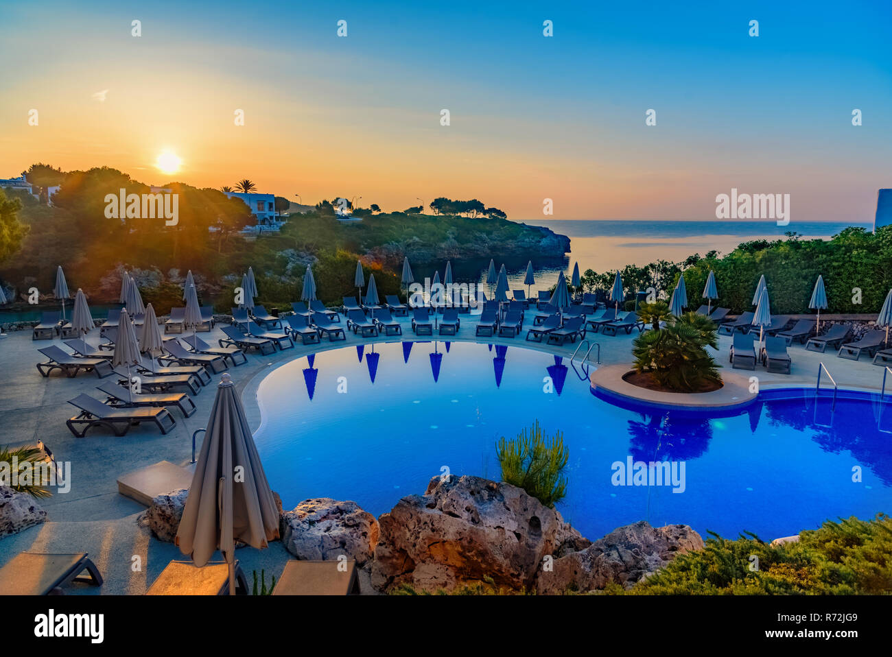 Beautiful sunrise above swimming pool resort on the coast of Mallorca ...