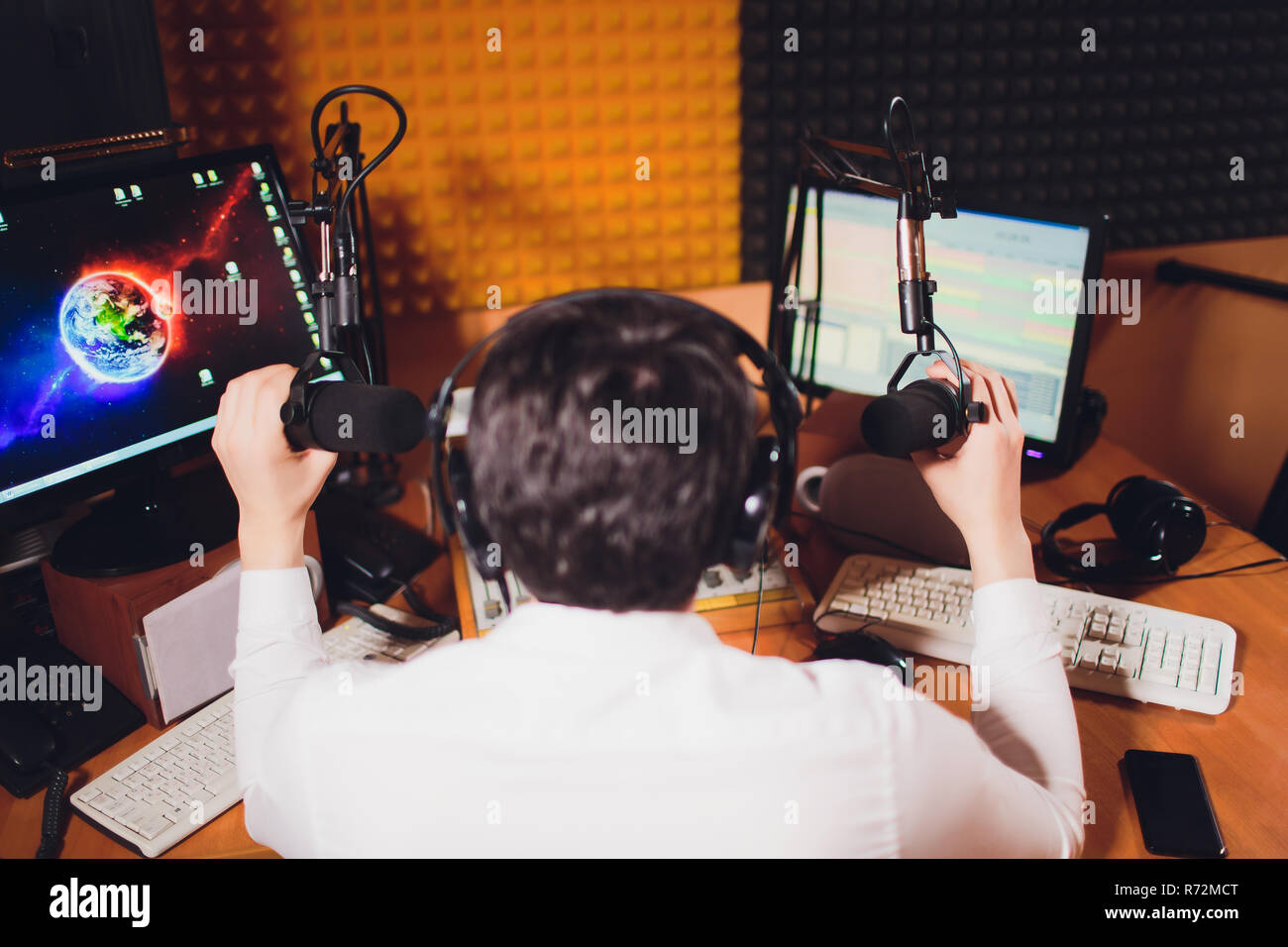 Portrait of radio host using sound mixer on table in studio Stock Photo ...
