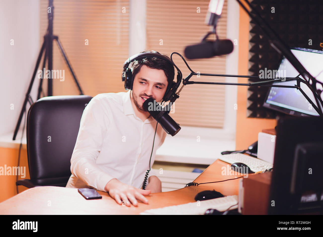 Portrait of radio host using sound mixer on table in studio Stock Photo ...