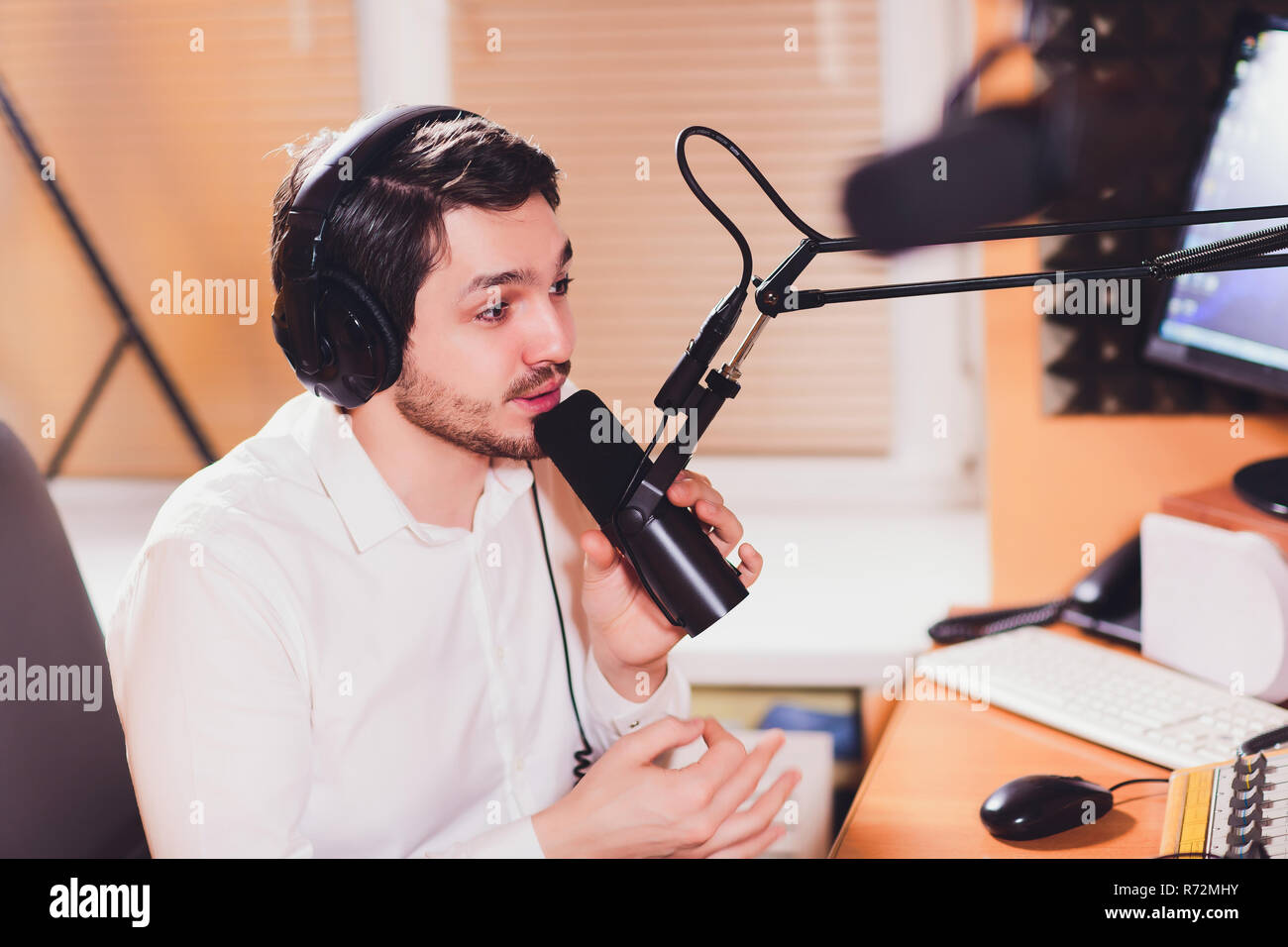 Portrait of radio host using sound mixer on table in studio Stock Photo ...
