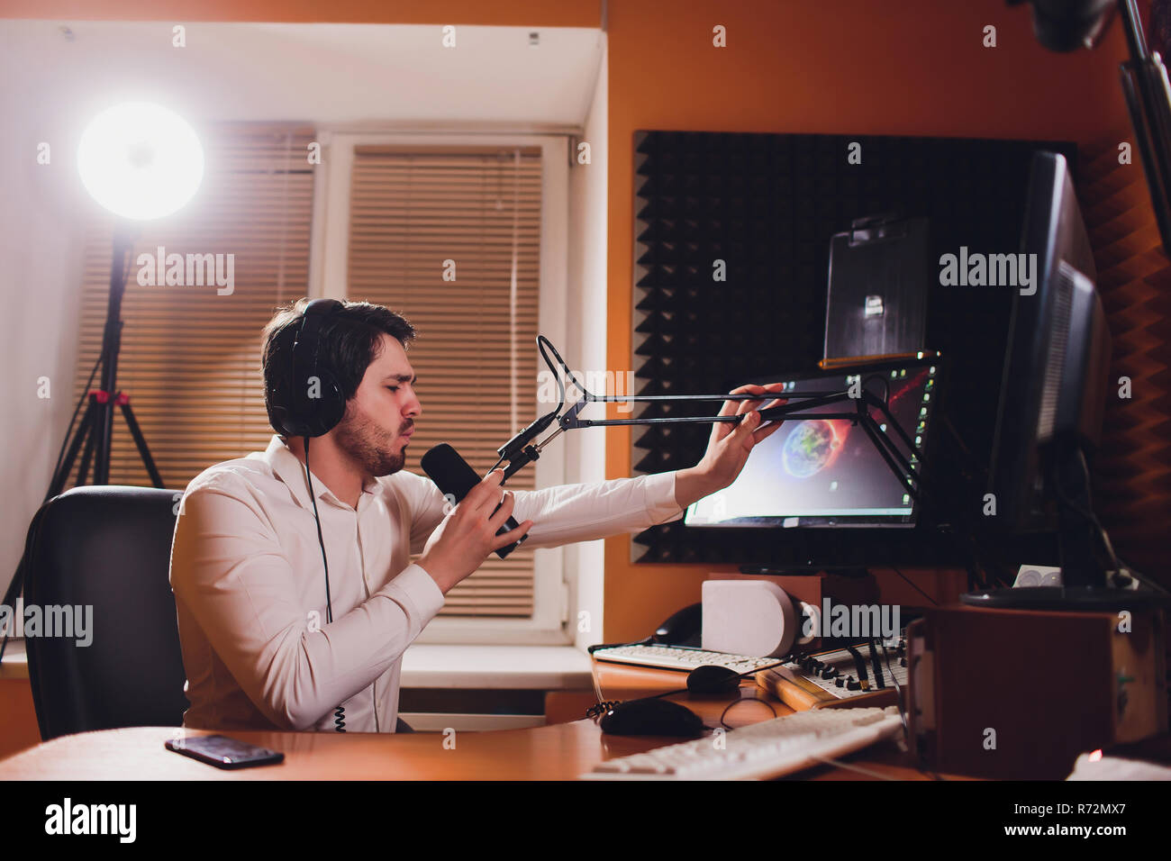 Portrait of radio host using sound mixer on table in studio Stock Photo ...