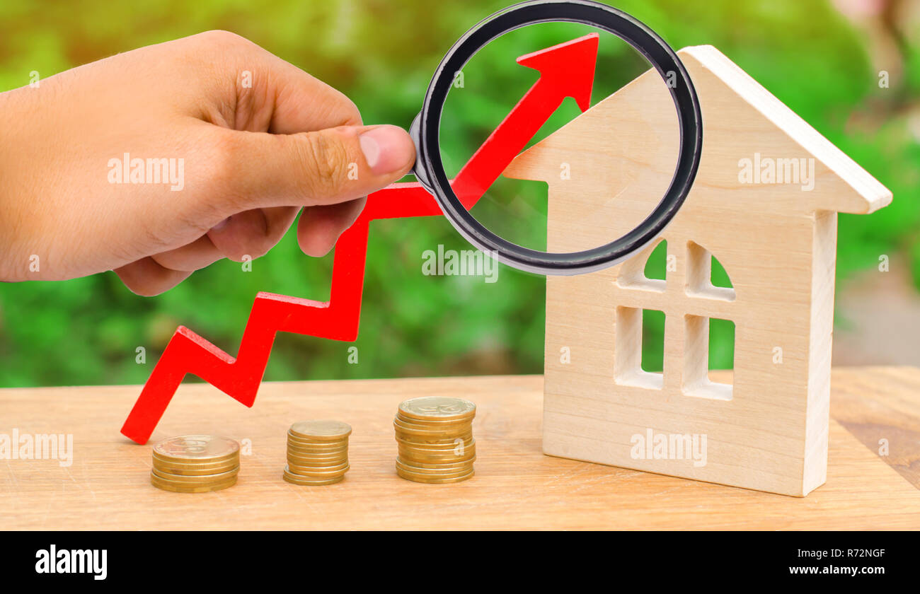 wooden house with a coins and red arrow up. concept of high demand for ...