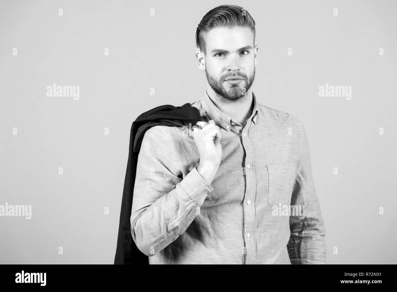 Macho in blue shirt pose with jacket on shoulder on grey background ...
