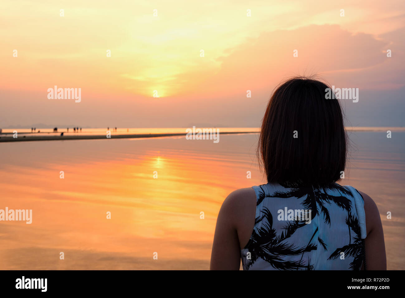 Woman watching Sunset at the beach Stock Photo - Alamy