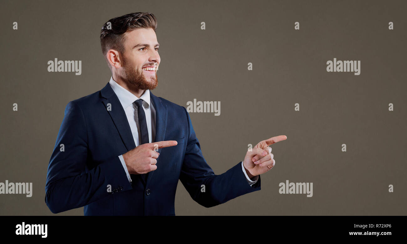 Handsome man in suit pointing away Stock Photo - Alamy