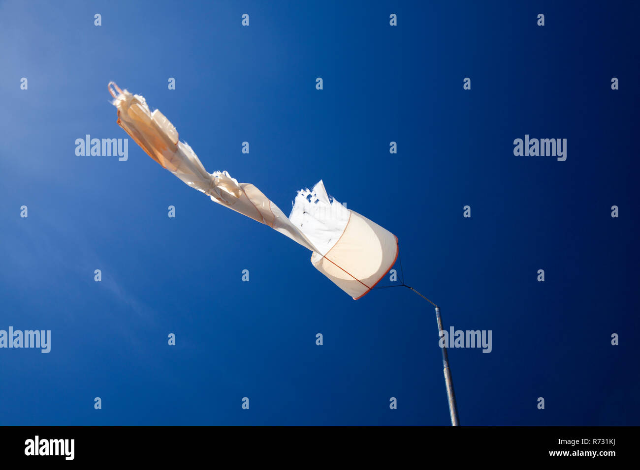 torn windsock against dark blue sky, storm aftermath background Stock ...