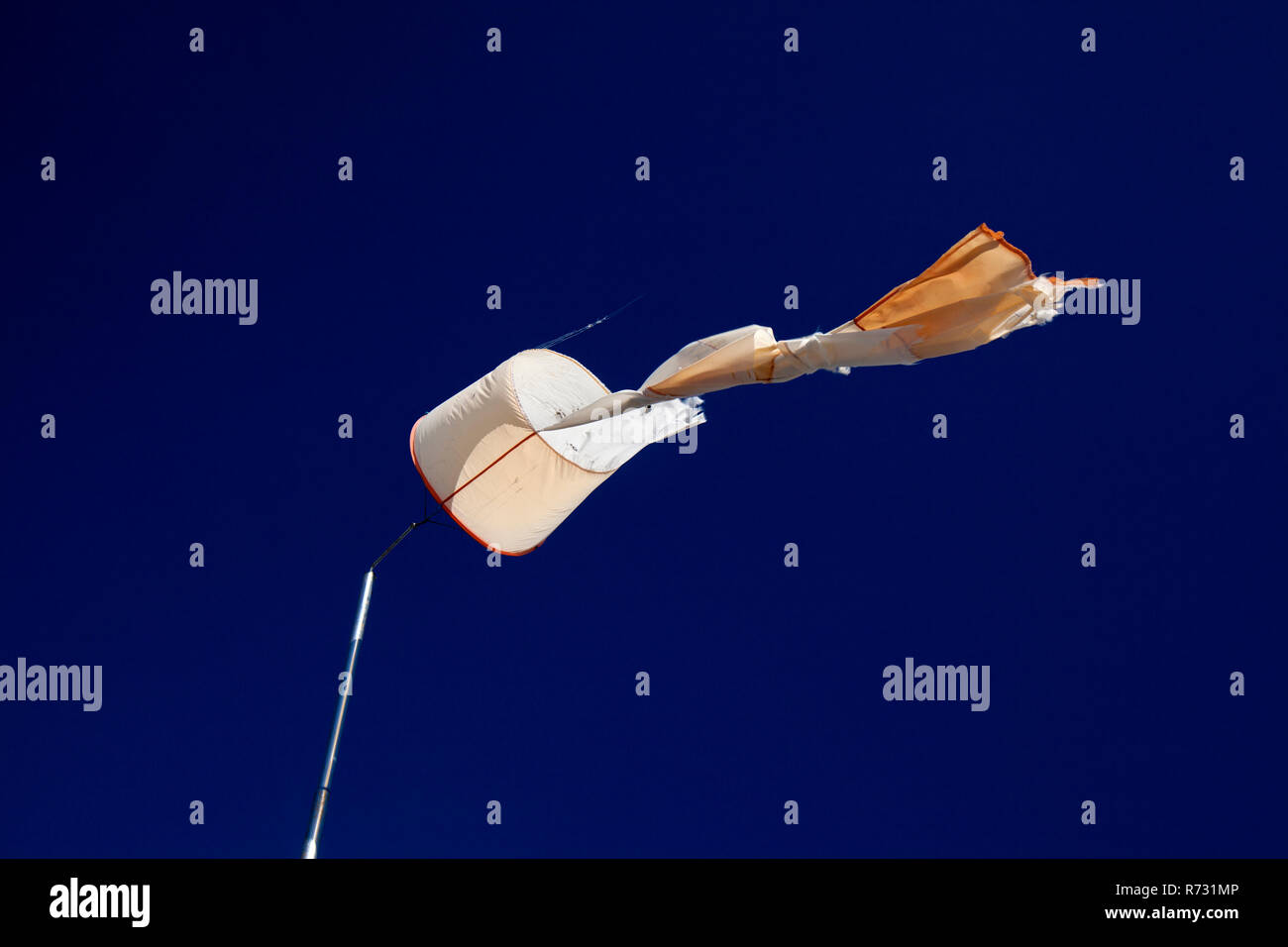 torn windsock against dark blue sky, storm aftermath background Stock ...
