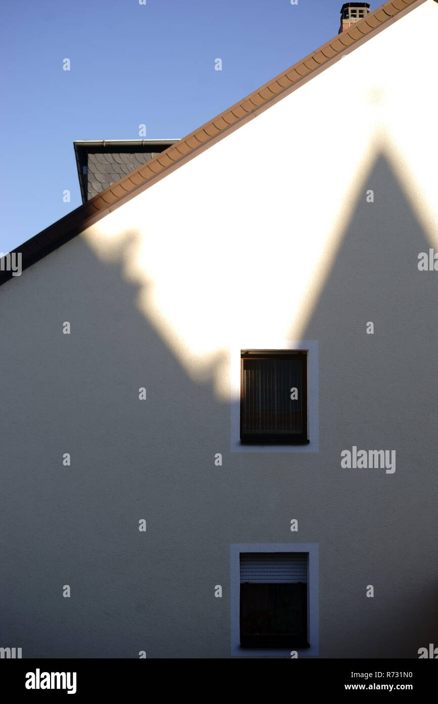 The outline and shadow of a residential building on the wall of a ...