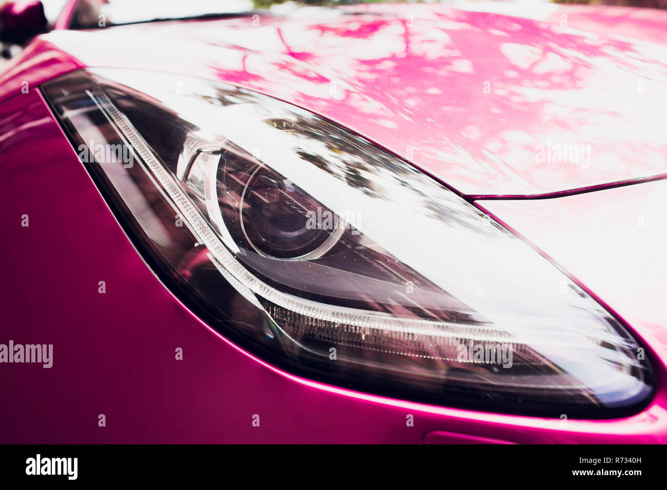 Headlights and hood of sport pink car with silver stars Stock Photo - Alamy