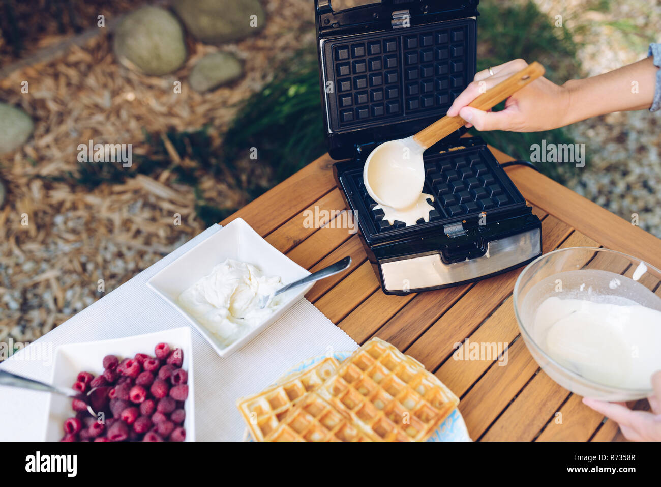 Preparation of homemade waffles. Pouring dough into waffle irons with a ...