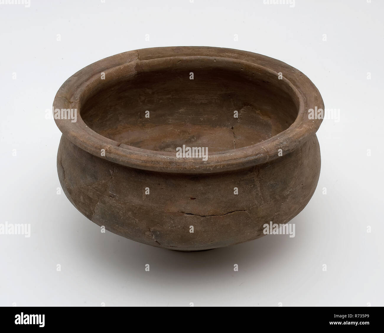 Small brown pot on narrow stand, baluster shape with grooved top edge ...