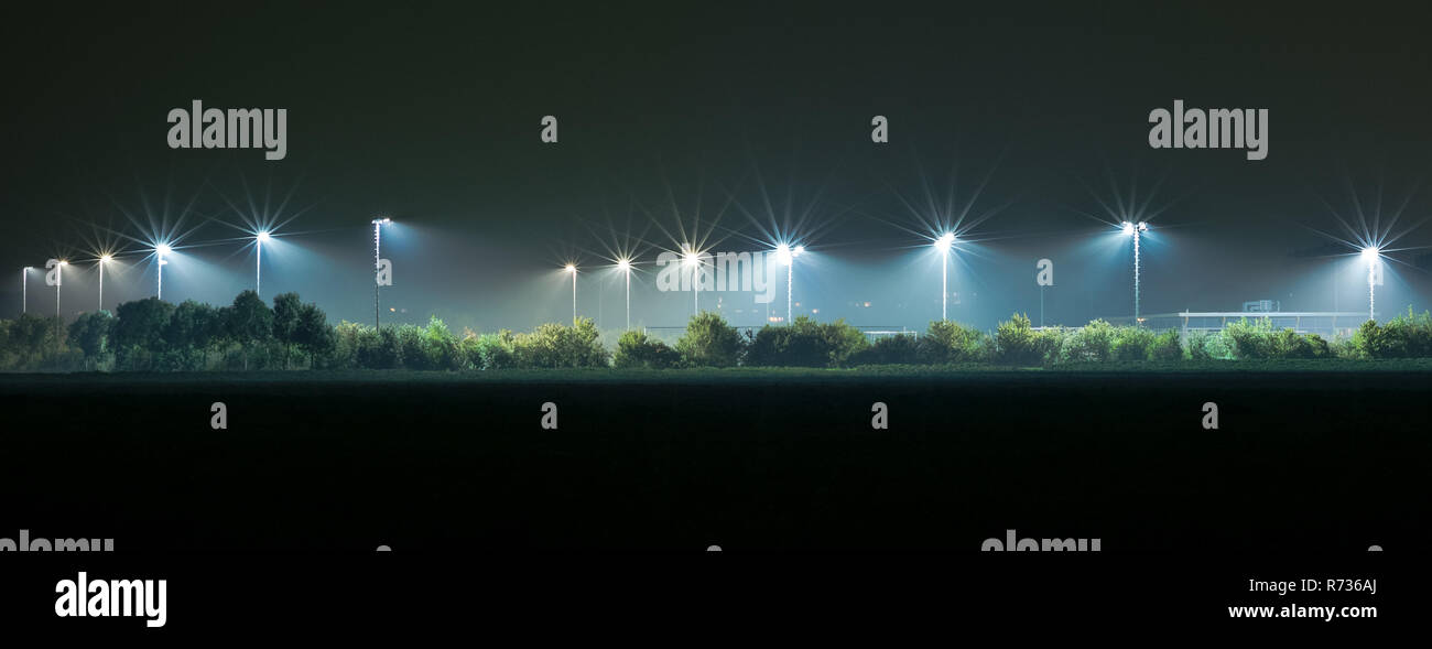 Athletic field illuminated by bright lights in the dark. Panoramic view ...